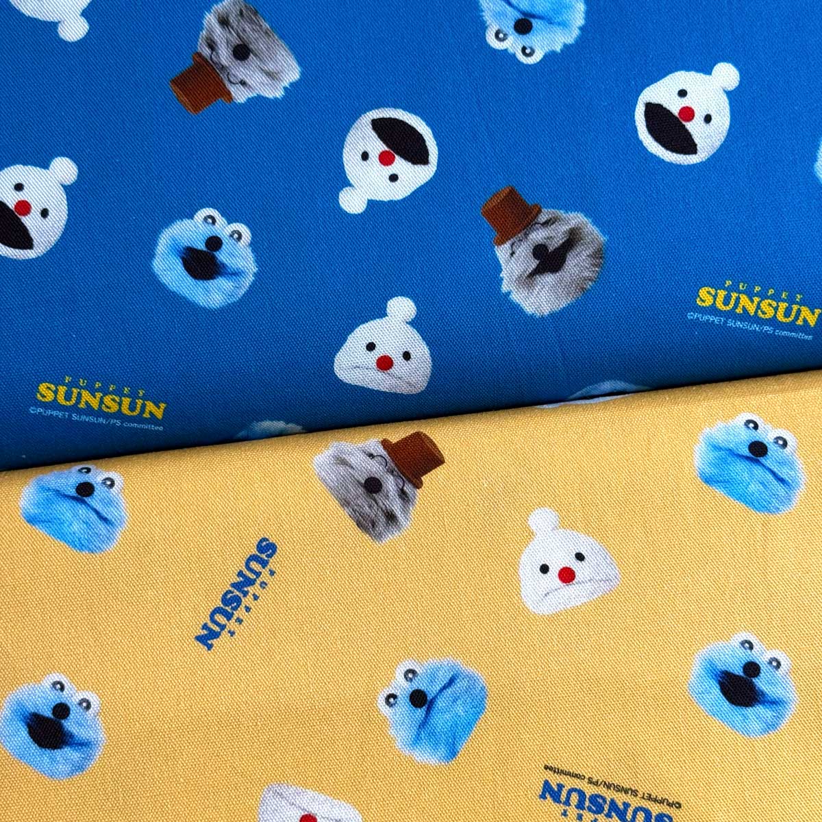 パペットスンスン フェイス柄 オックス生地 インクジェットプリント ブルー/イエロー(PUPPET SUNSUN キャラクター 入園入学通園 ...